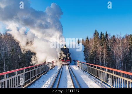 Retro steam train moves above the river Stock Photo - Alamy