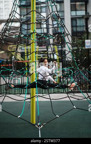 Happy young woman climbing the pyramid at the Spartan Race competition ...
