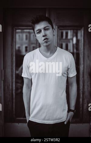 Guy stand on the background of the building, look camera and around ...