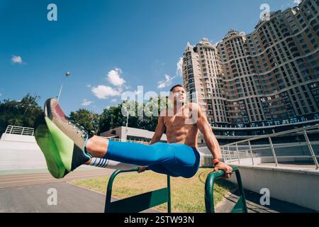 Strong man doing exercises on uneven bars in outdoor street gym Stock ...