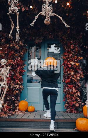 A girl with a pumpkin mask on her face for Halloween Stock Photo - Alamy
