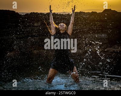 Middle-aged woman dancing and throwing water in the air Stock Photo - Alamy