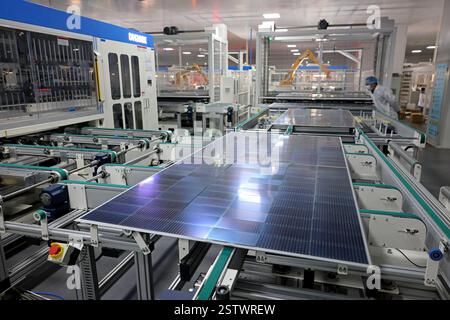A worker produces photovoltaic modules in an intelligent workshop at a ...