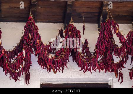 Red peppers drying on a facade Stock Photo - Alamy