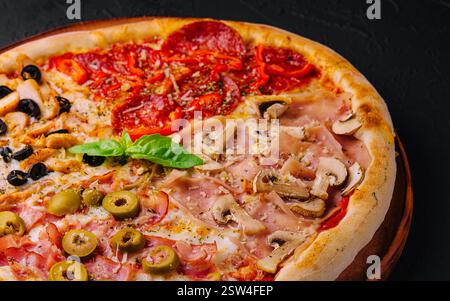 tasty pizza with pepperoni ham and bacon on black dough Stock Photo - Alamy