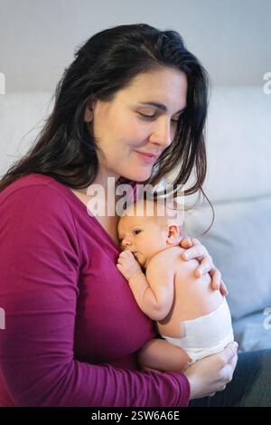 Mom is embracing her infant child with tenderness and affection in a ...