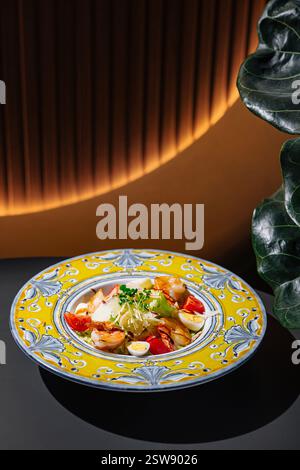 Caesar salad with shrimps, on a plate, on a dark background. With place ...