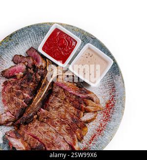 Sliced beef steak with sauces. On cutting board. Top view flat lay with ...