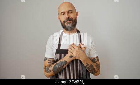 Hispanic man with tattoos standing over blue background clueless and ...