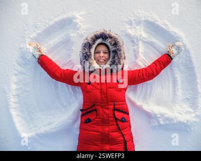 Snow angel made by a happy woman in the snow. Top flat overhead view ...