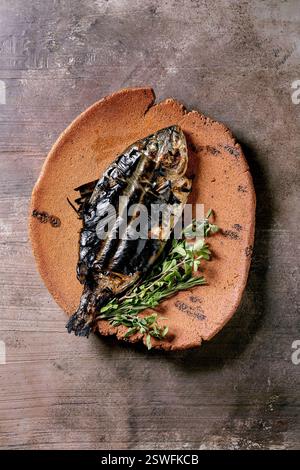 Grilled cooked fresh gutted sea bream or dorado fish on ceramic plate ...