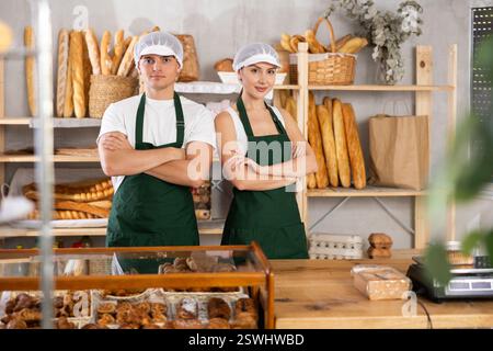 Young woman and guy sellers at counter in bakery Stock Photo - Alamy