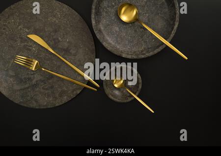 Black plate on tray with cutlery in brown napkin on grunge beige ...