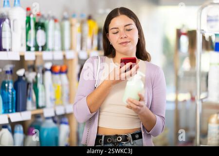 Checking expiration date of liquid hand soap - female shopper scans QR ...