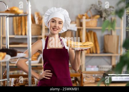 Smiling woman baker offers to buy fresh delicious bocadillo Stock Photo ...