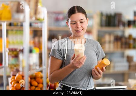 Woman choosing sauce in the store Stock Photo - Alamy
