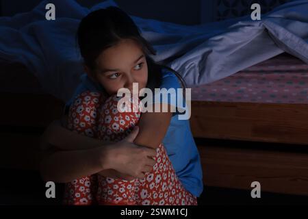 Afraid girl near bed in her room at night Stock Photo - Alamy