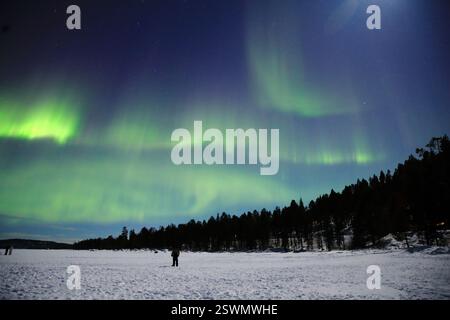 People observing the Aurora Borealis seen at lake Inari, Northern ...