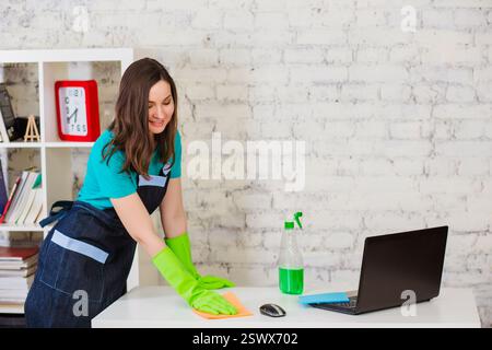 Worker Cleaning Computer Desk With Spray And Sponge Stock Photo - Alamy