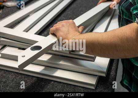 Aluminum profiles. Assembling aluminum frames in the factory Stock ...
