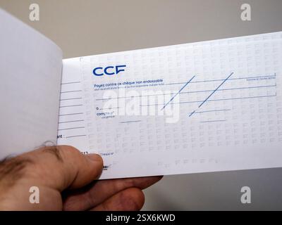 Paris, France - Dec 20, 2024: Person holding a CCF branded blue cheque ...