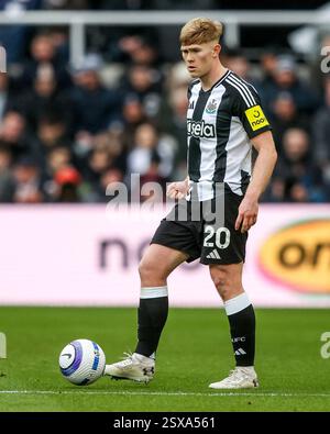 Lewis Hall of Newcastle United runs after the ball with Pedro Neto of ...