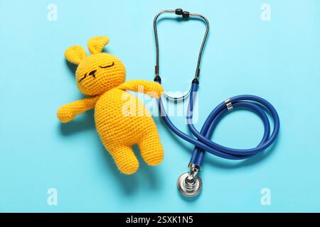 Pediatrics concept. Toy bunny with stethoscope on light blue background ...