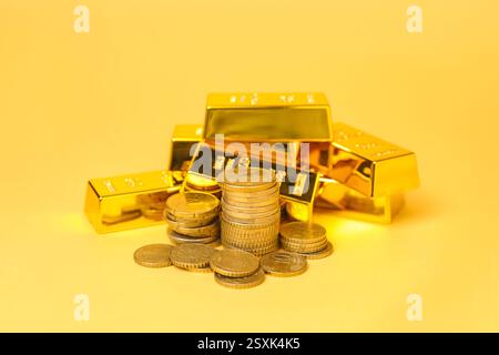 Gold bars and coins on pale yellow background, closeup Stock Photo - Alamy