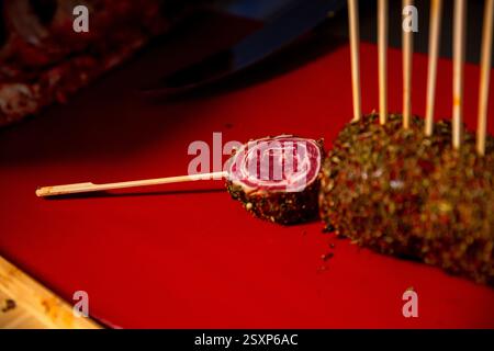 Row beef roulade cuts with skewers on a red cutting board. Barbecue ...