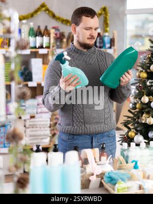 Middle-aged man choosing detergent in big supermarket Stock Photo - Alamy