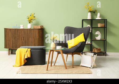 Interior of living room with armchair and mimosa flowers in vases Stock ...