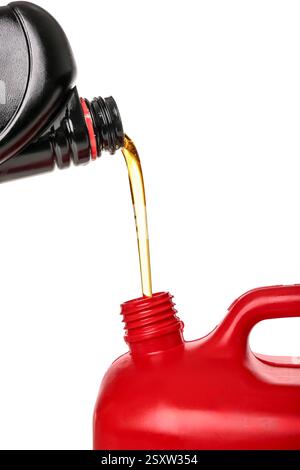 Pouring of gasoline from canister into bottle on black background ...