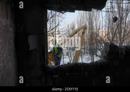 A municipal worker uses an aerial work platform at a building damaged ...
