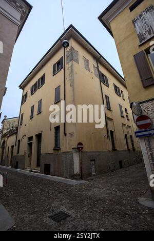 Crossing between cobbled streets partly in the shade at the corner of a ...