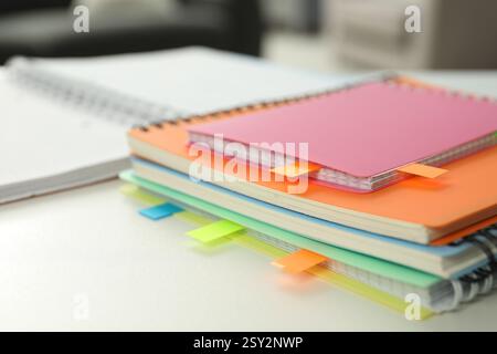 Notebooks with colorful tabs on light blue background, closeup. Space ...