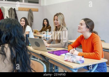 Group of students attentively listening to lecture of female teacher ...