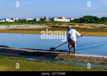 A man at work in the Long Dien salt field near Ba Ria, one of the most ...