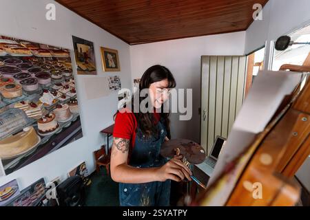 Young woman artist expressing creativity by painting on a canvas ...