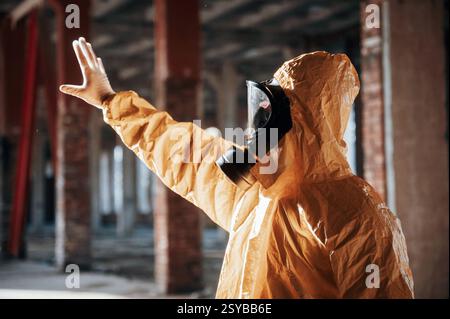 Nuclear explosion. Man dressed in chemical protection suit in the ruins ...