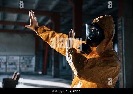 Nuclear explosion. Man dressed in chemical protection suit in the ruins ...