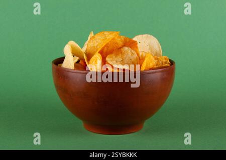 Potato chips in clay bowl isolated on black background. Top view Stock ...