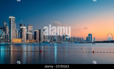 The skyline of Dubai Marina after sunset with a sea in the foreground ...