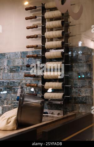 Traditional Hungarian chimney cakes (kürtőskalács) baking on rotating ...