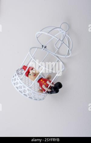 Metal cage and Little puppet pinocchio made of wood Stock Photo - Alamy
