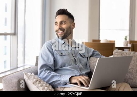 The handsome man is a buyer sitting in a car with a phone in a new car ...