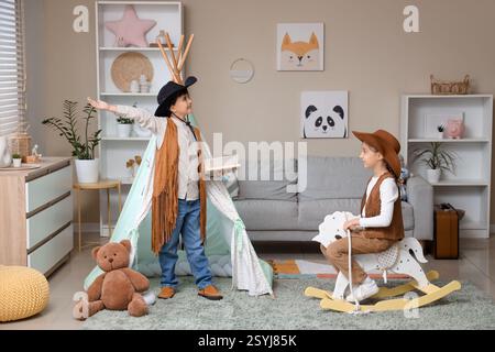 Cute children dressed as cowboys reading adventure book at home Stock ...