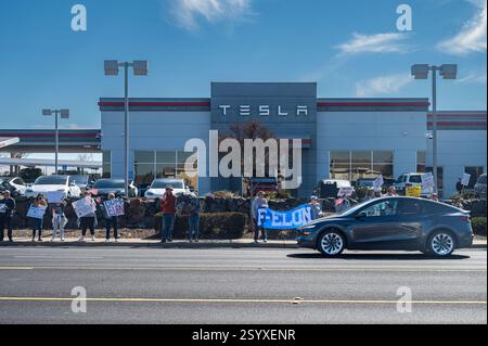 People protest outside a Tesla dealership as part of a coordinated ...
