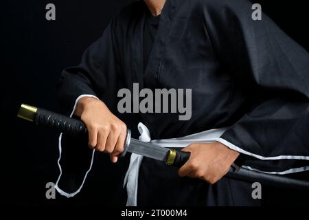Samurai warrior gripping the sword with a black background Stock Photo - Alamy
