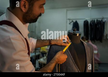 A bespoke tailor checking measurements on a dress form Stock Photo - Alamy