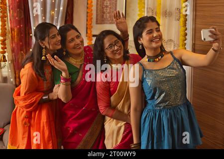 Portrait of three generation family clicking selfie together at home on ...